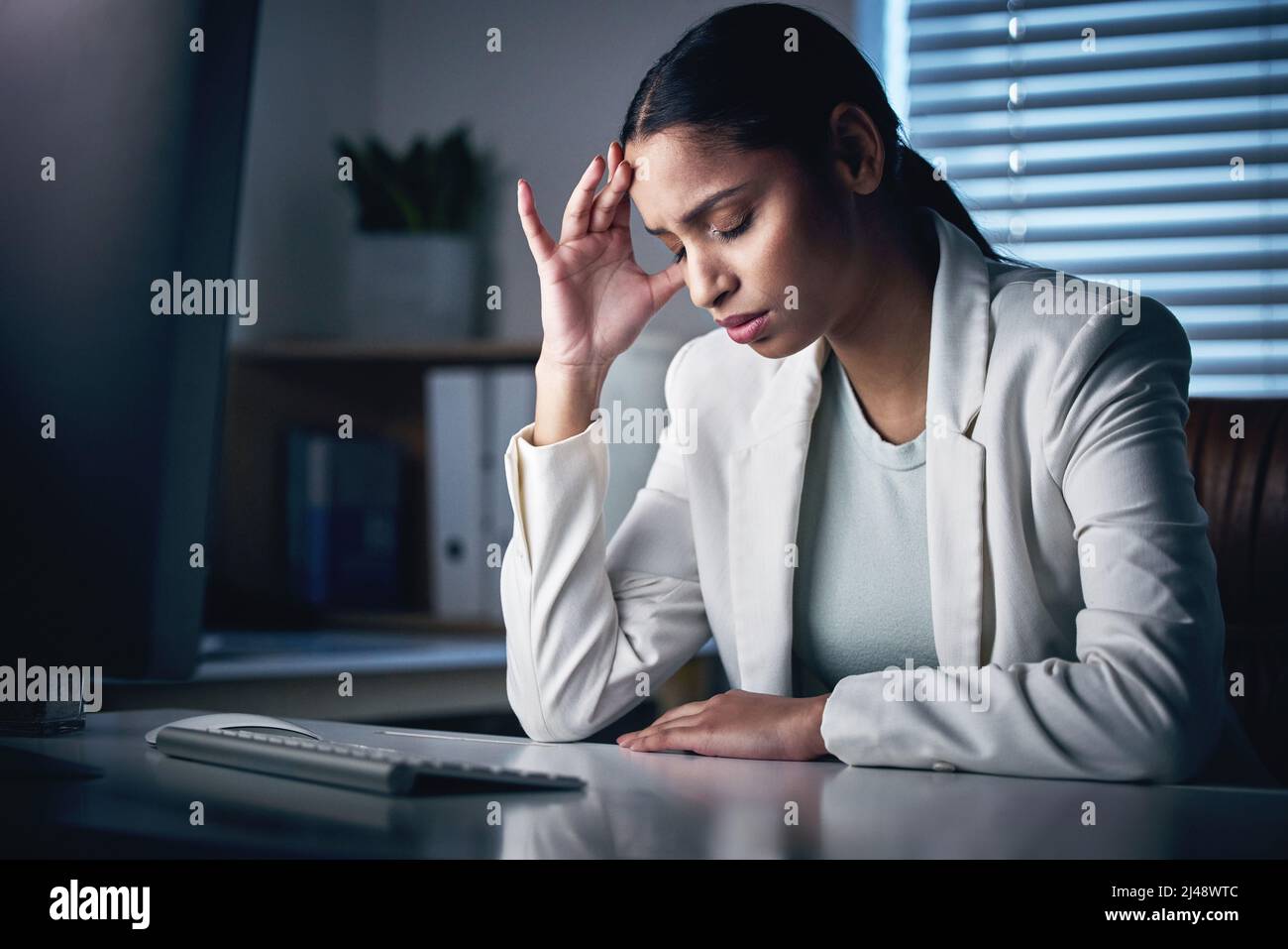 Im in for a long night. Shot of an attractive young businesswoman ...