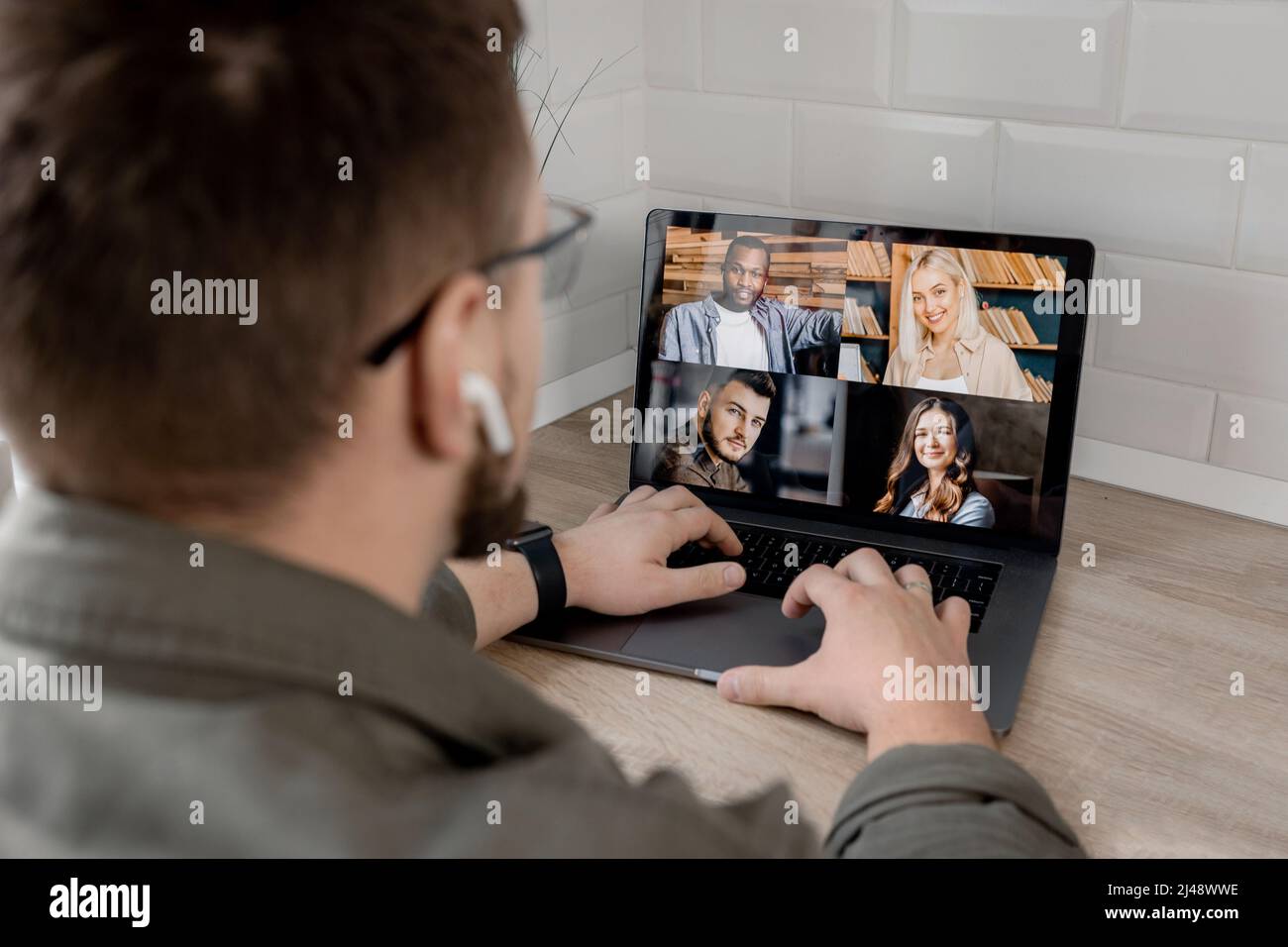 Back view of male employee having an online conference with colleagues ...
