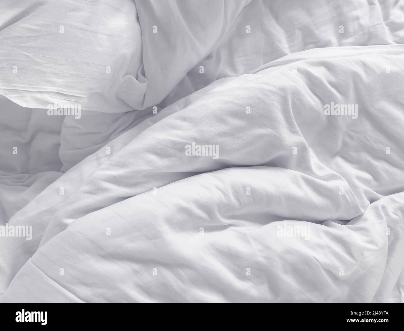 Messy white bed duvet cover as background Stock Photo - Alamy