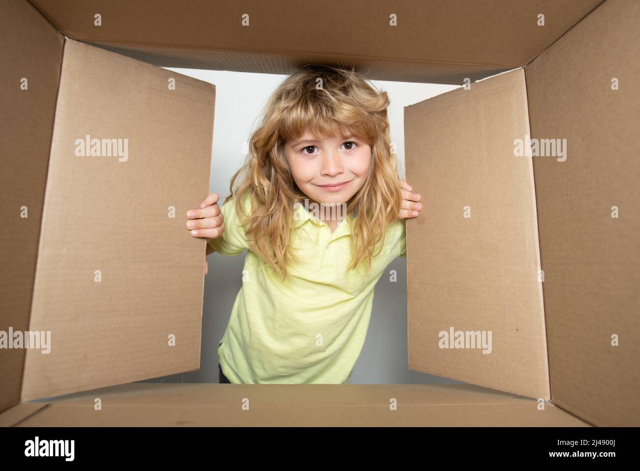 Kid open paper cardboard box. Cheerful cute child opening a present ...