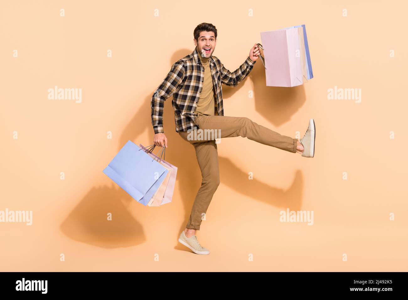 Full size photo of cheerful guy hold packages bought on low price ...