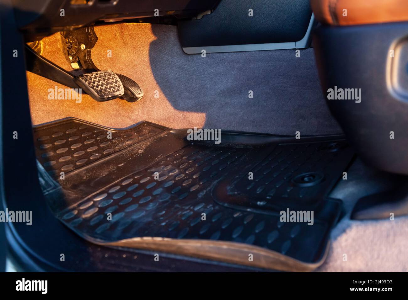 Dirty car floor mats of black rubber under passenger seat in the ...