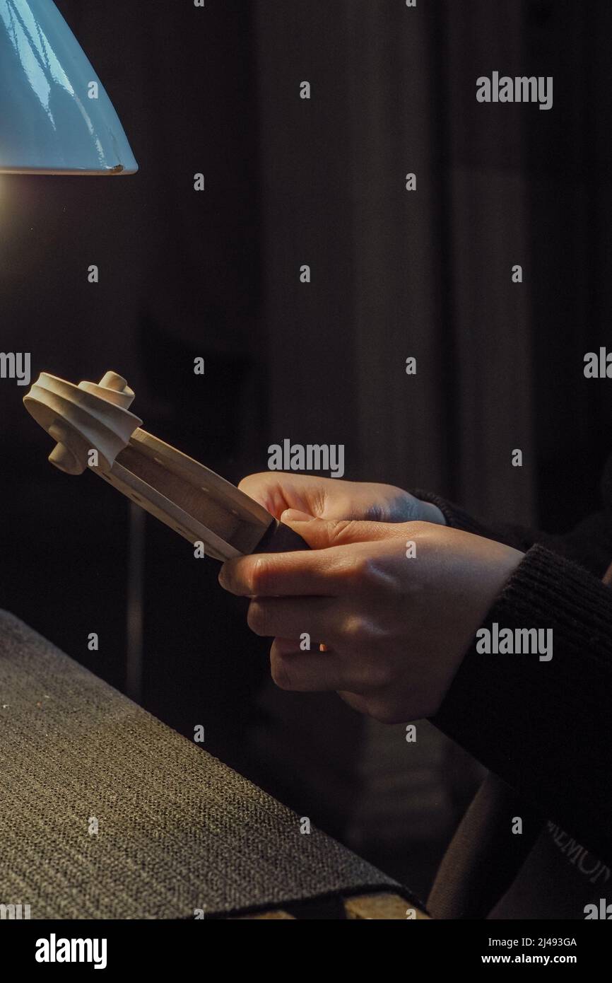 Luthier at work with a violin scroll in his workshop Stock Photo - Alamy