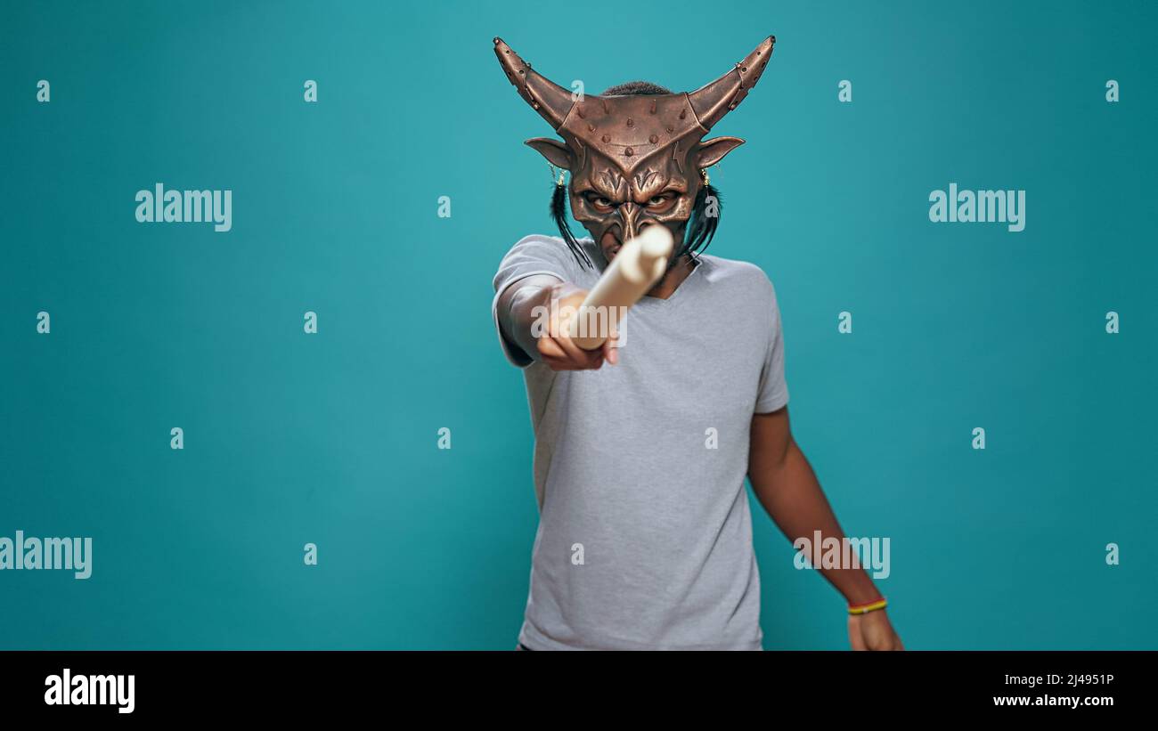 Festive man with traditional ceremonial mask using paddle, standing ...