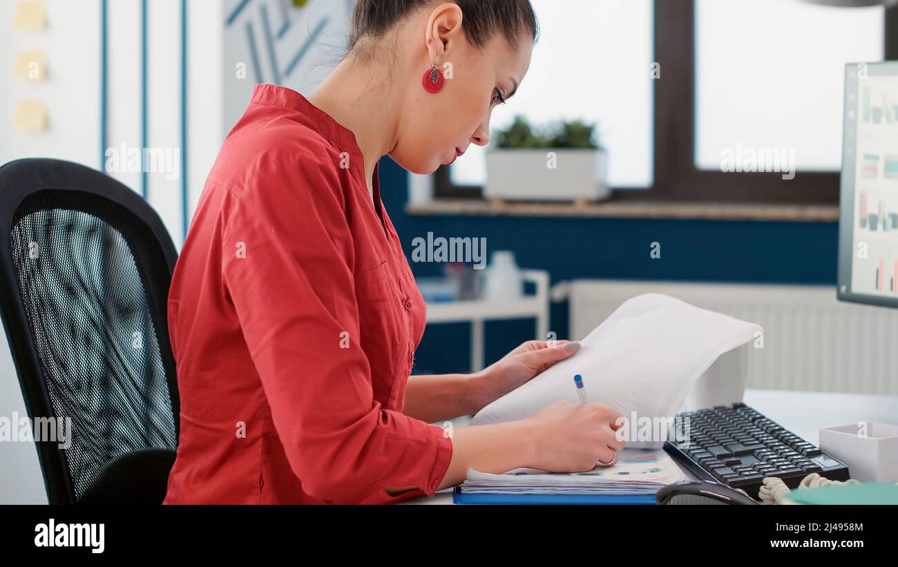 Female accountant taking notes on business documents to create ...