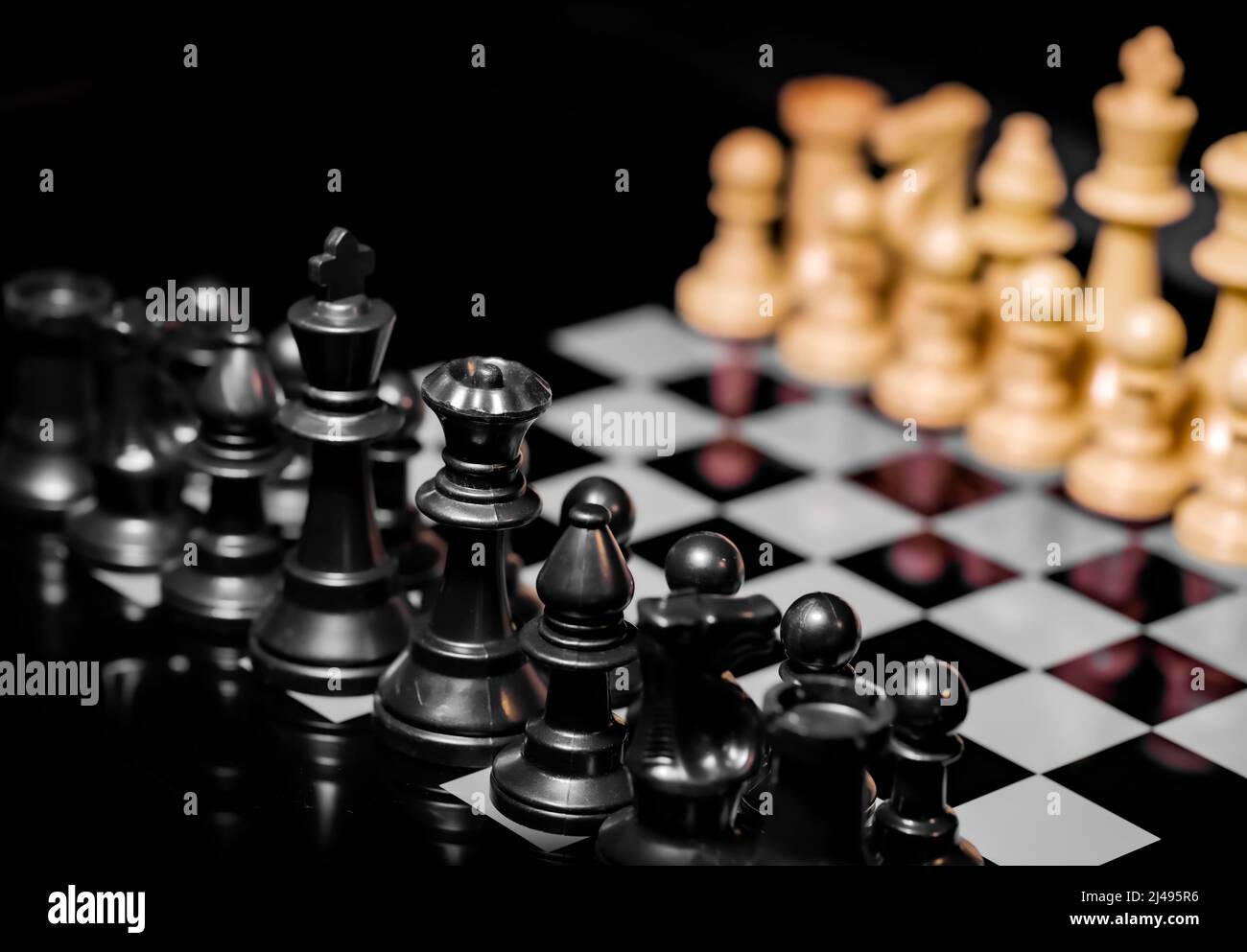 Close up of Chess pieces on a reflective mirror board surface with a ...