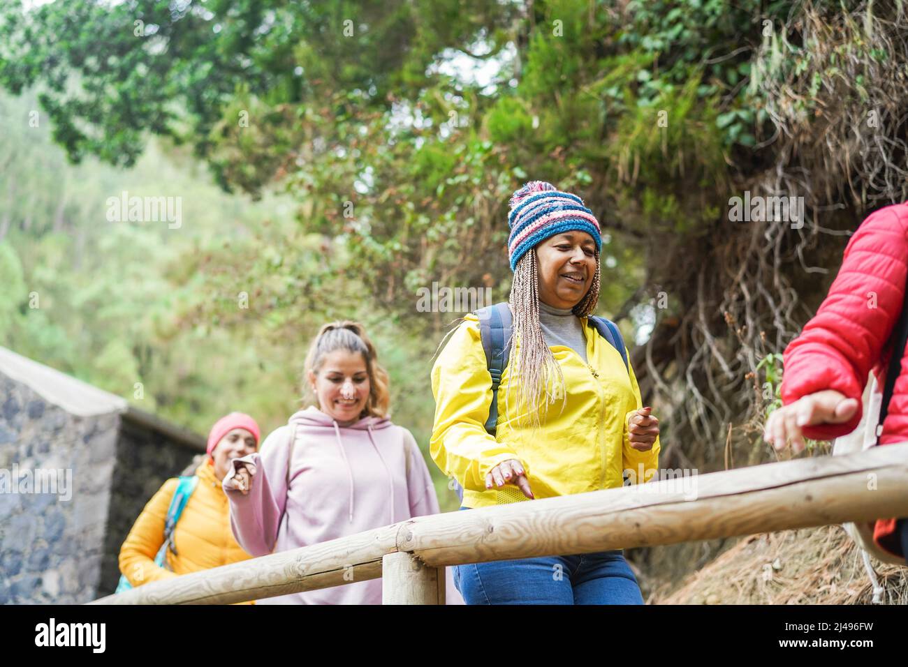 Multiracial women having fun exploring nature on trekking day in ...