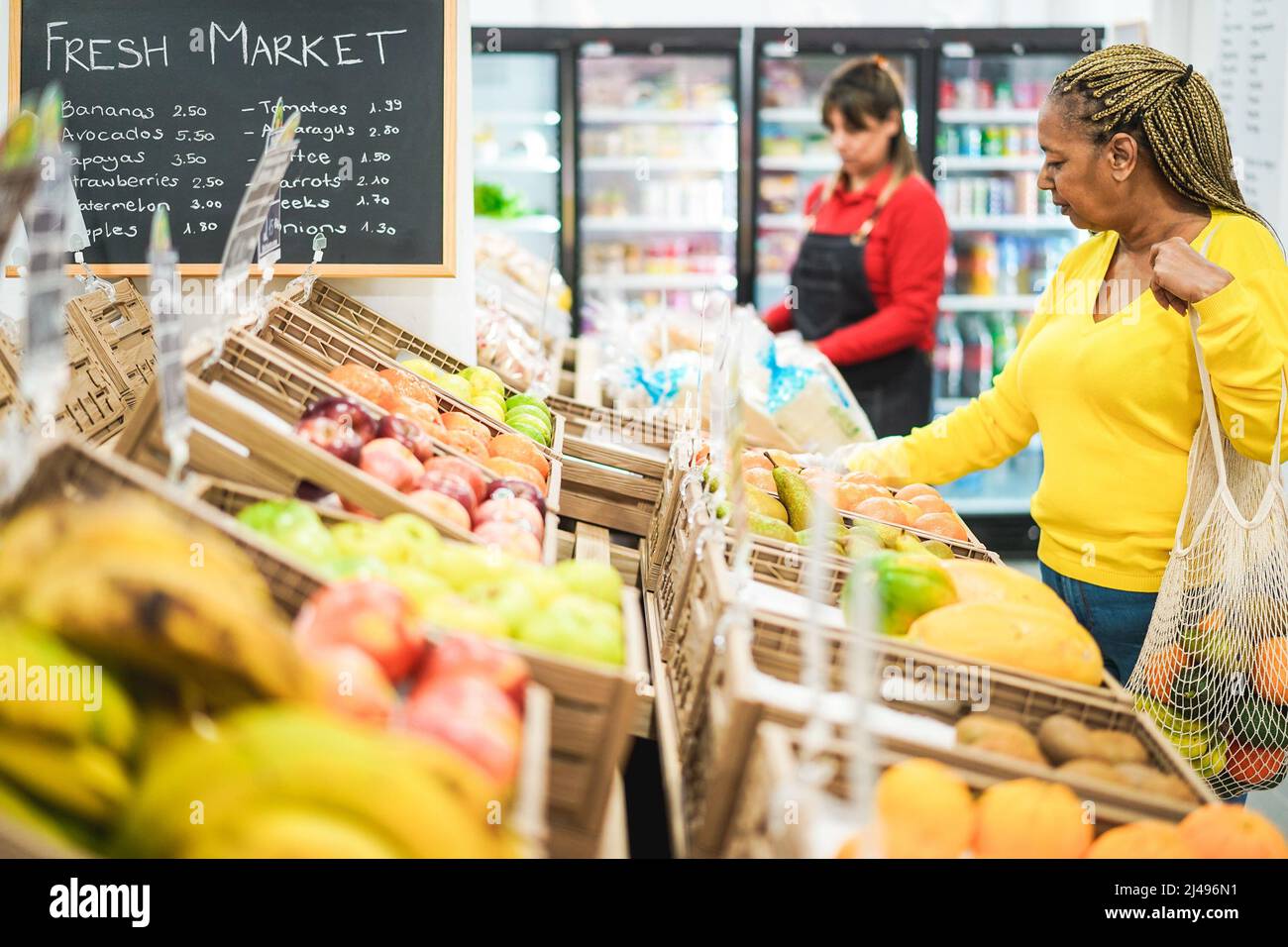 Female customer buying organic food fruits inside eco fresh market ...