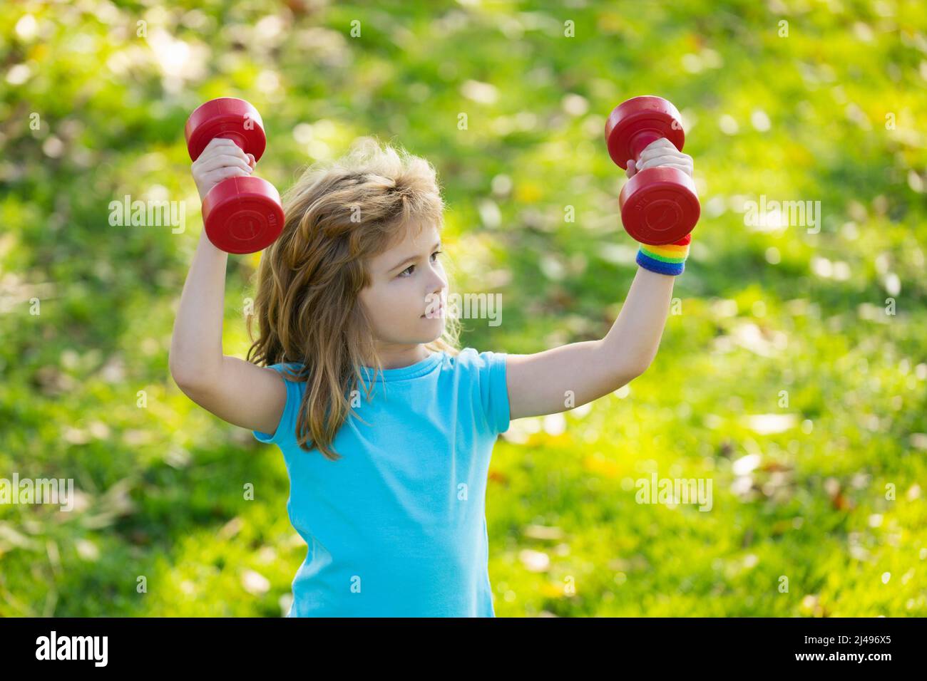 Cute boy workout in park. Kid sport. Child exercising with dumbbells ...