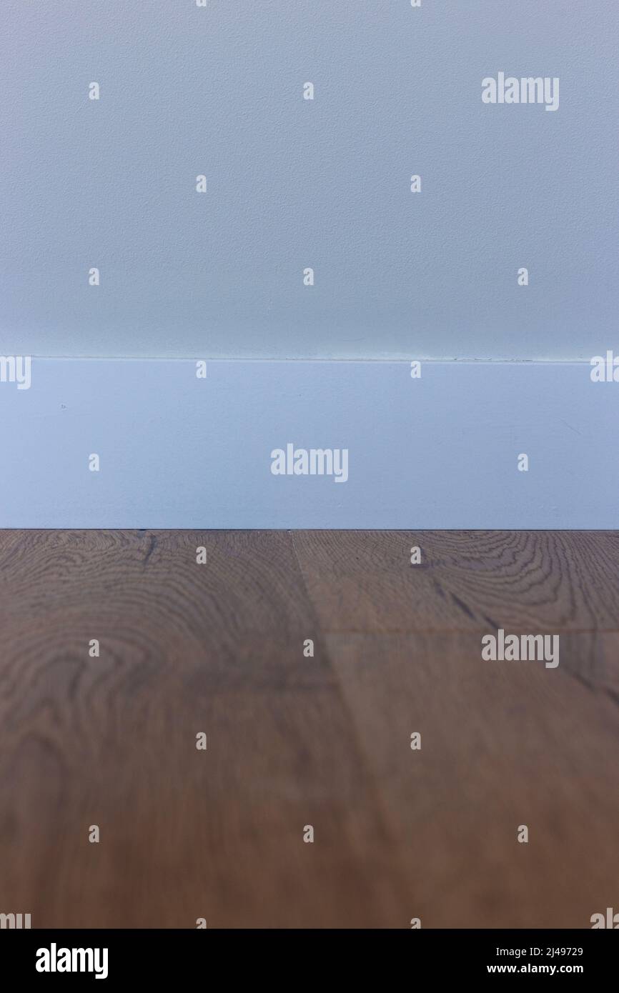 White baseboard, white wall and wood laminate Stock Photo - Alamy