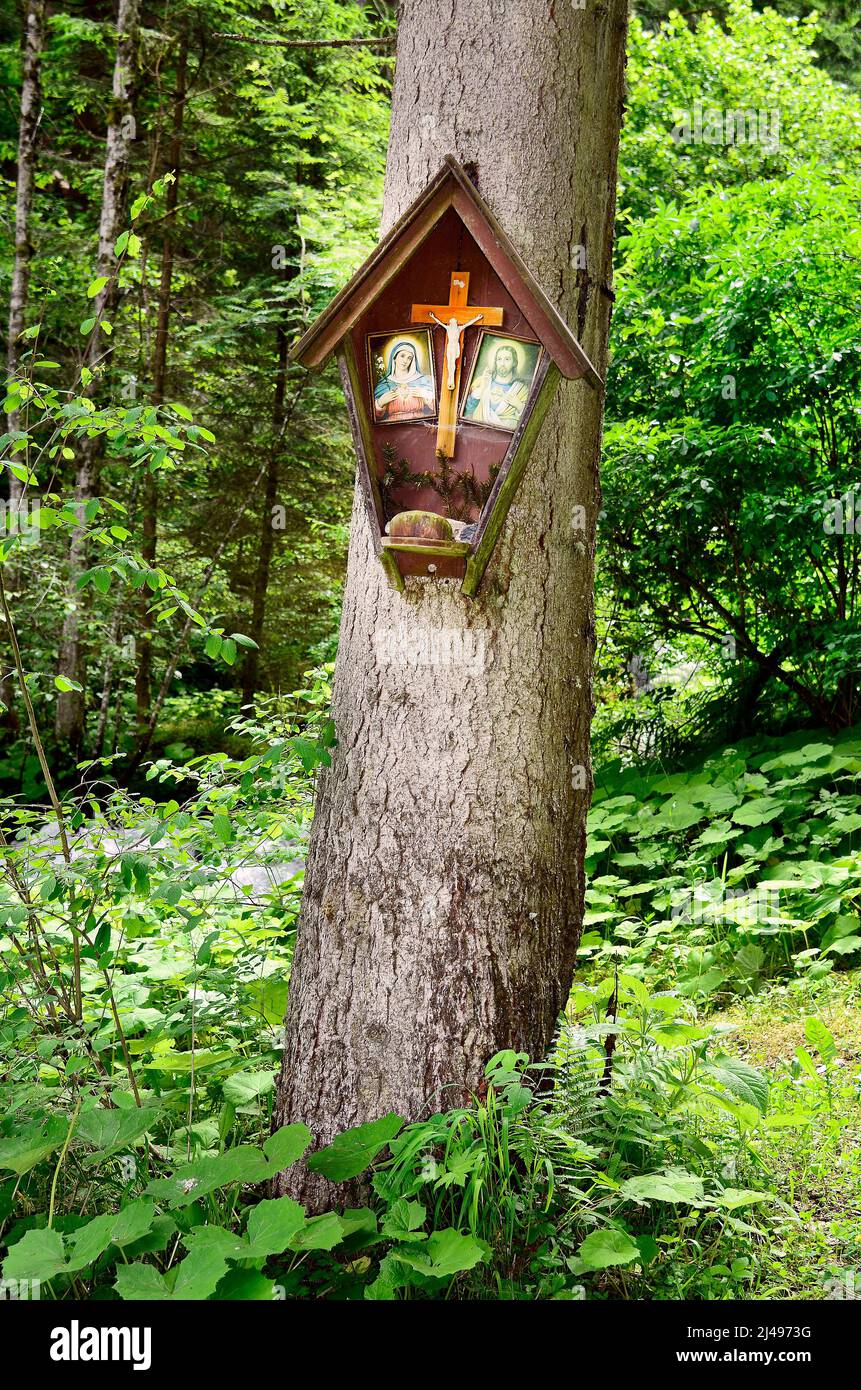 Austria, Tyrol, wayside shrine on tree trunk Stock Photo - Alamy