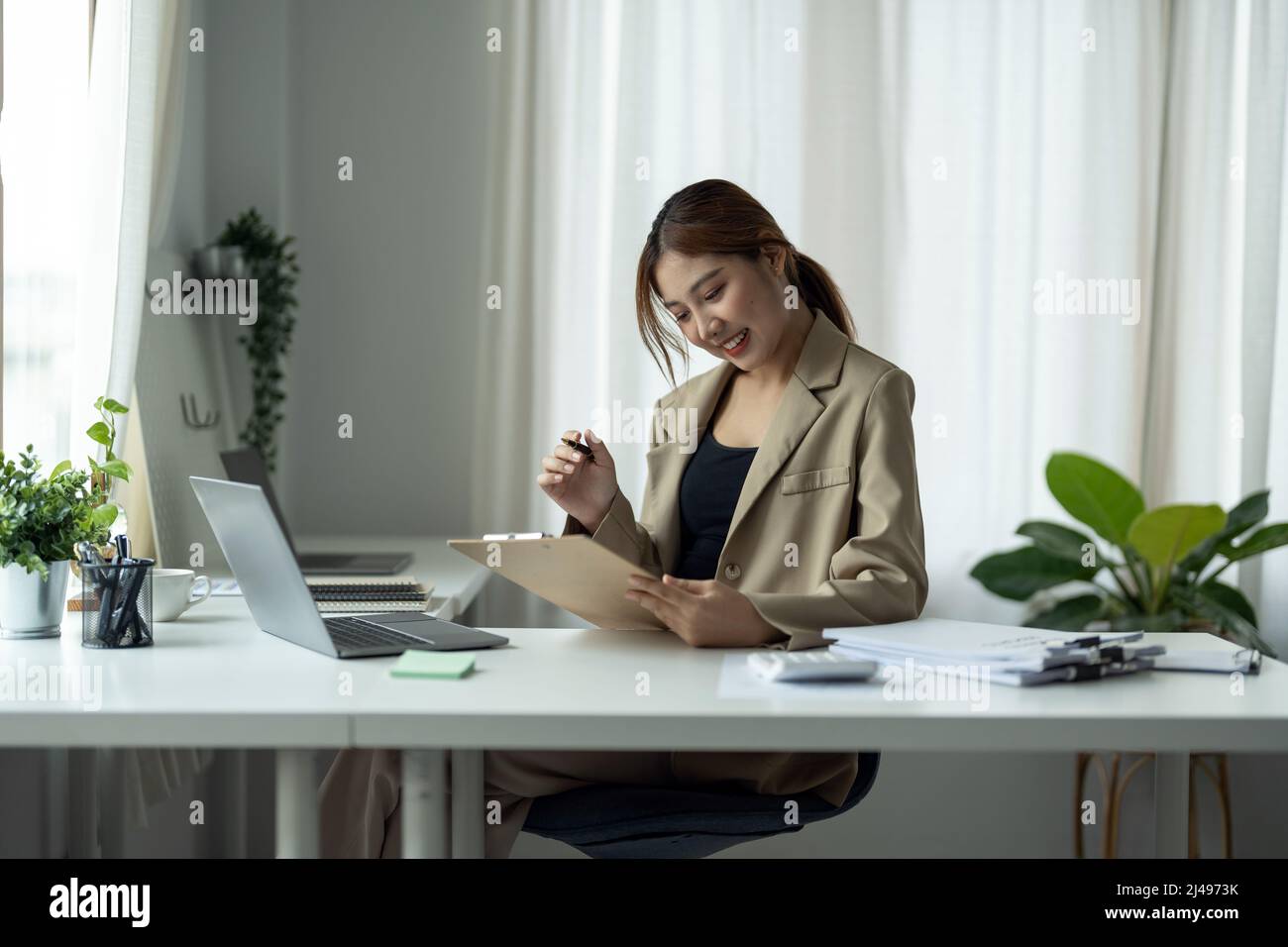 Young asian business woman checks charts and refreshes financial ...