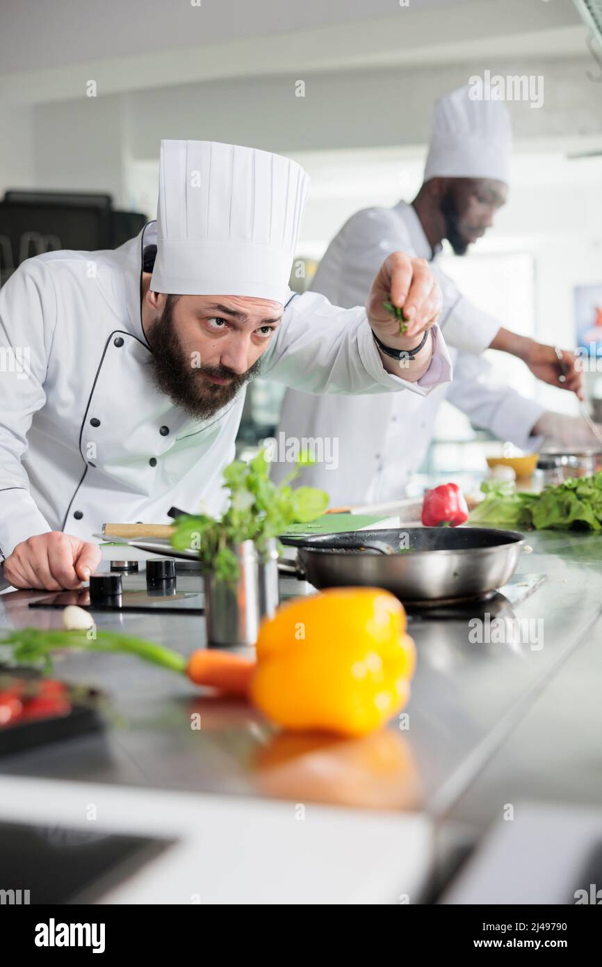 Chef adding herbs pan vegetables hi-res stock photography and images ...