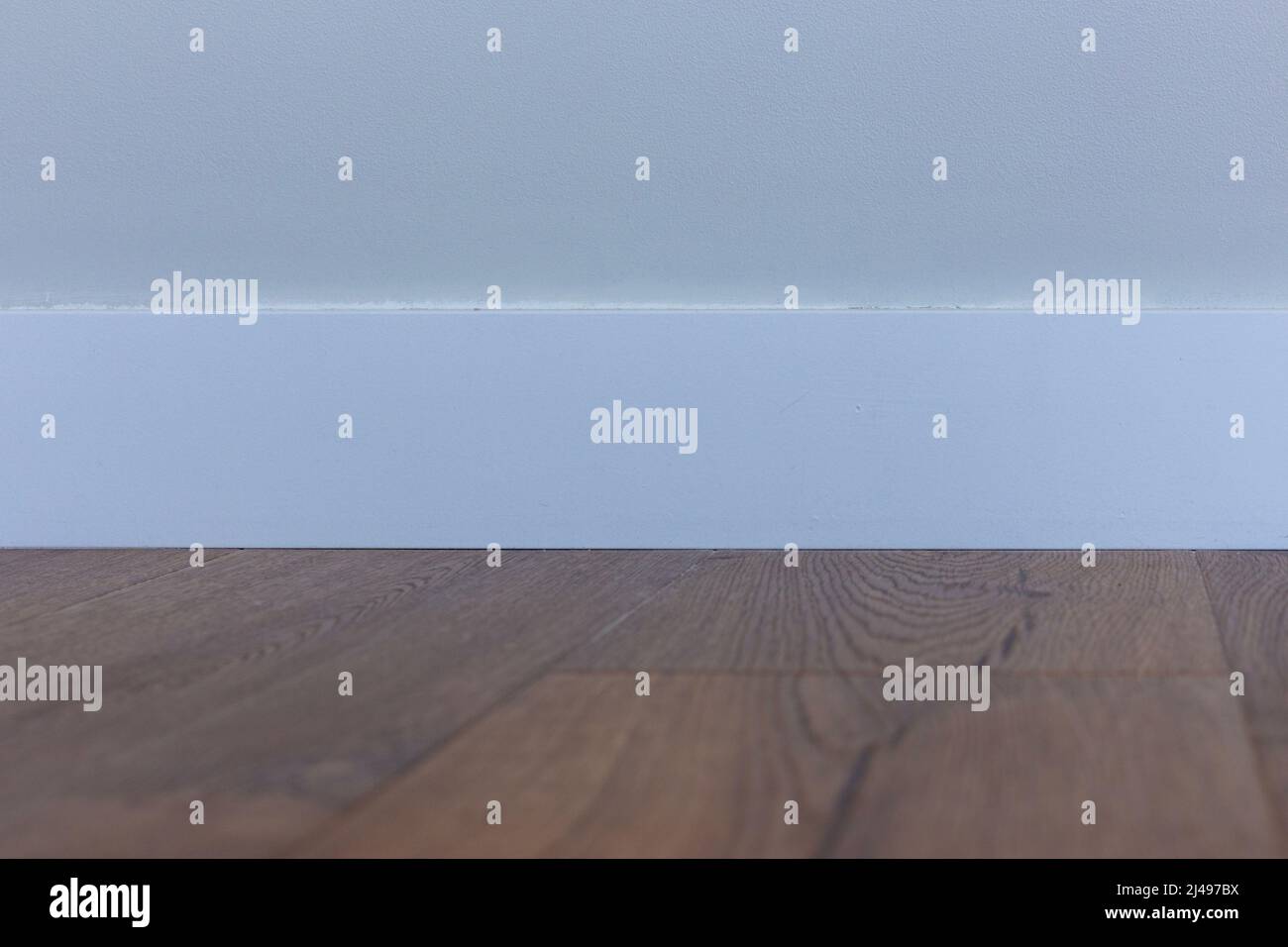 White baseboard, white wall and wood laminate Stock Photo - Alamy