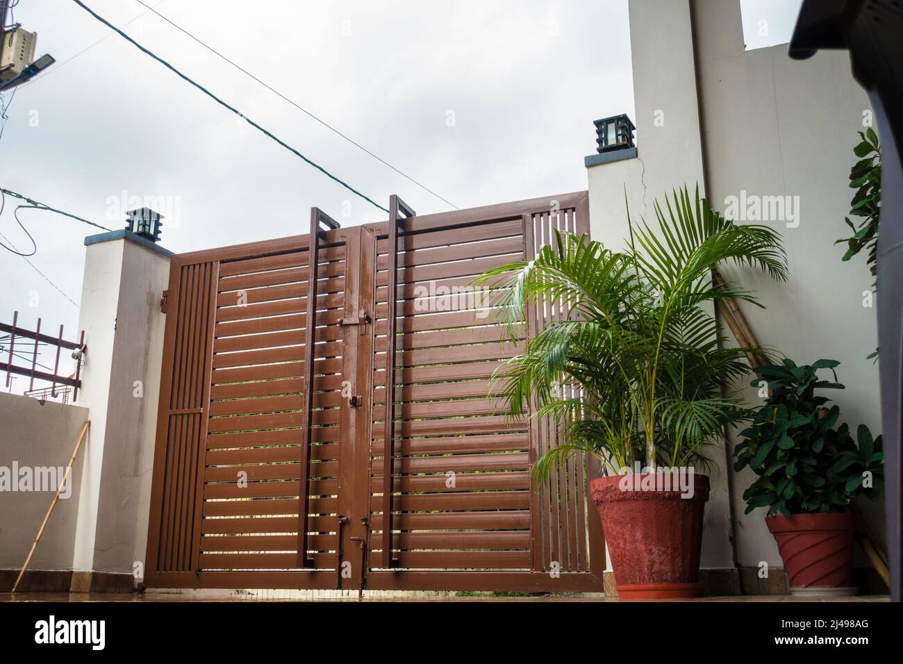 A large metal gate outside a residential home in India with flower pot ...