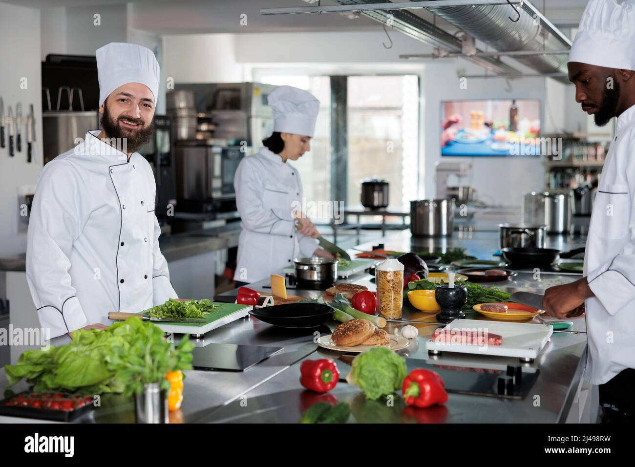 Positive smiling head chef in restaurant professional kitchen space ...