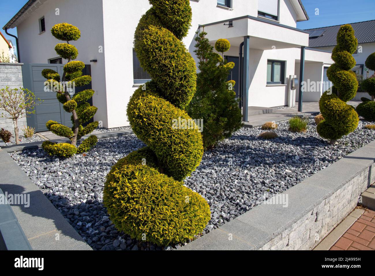 Modern and well-kept front garden with decorative chippings and ...