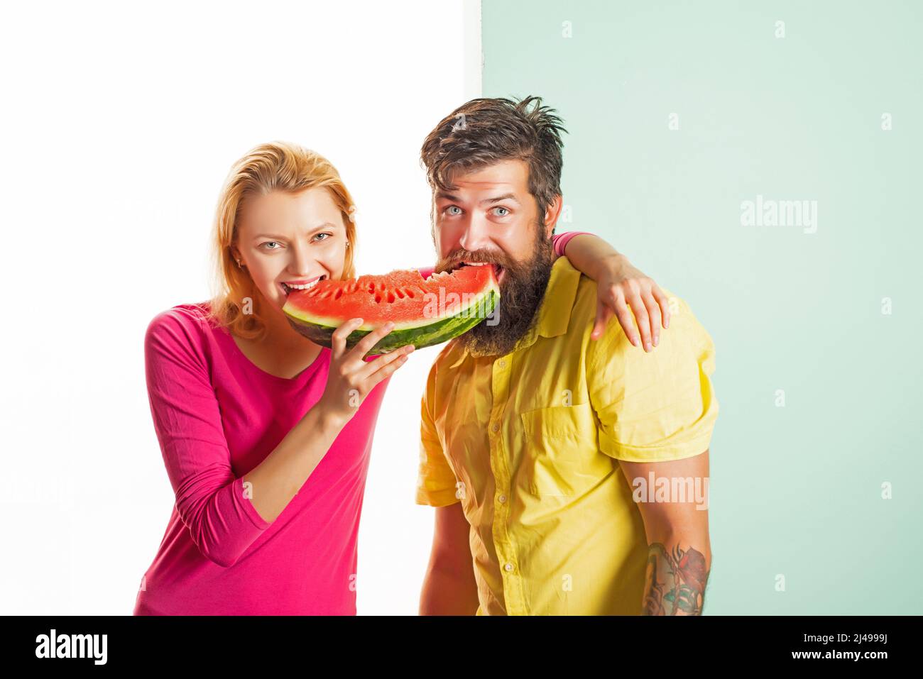 Young couple eating watermelon. The cheerful love couple eating slices ...