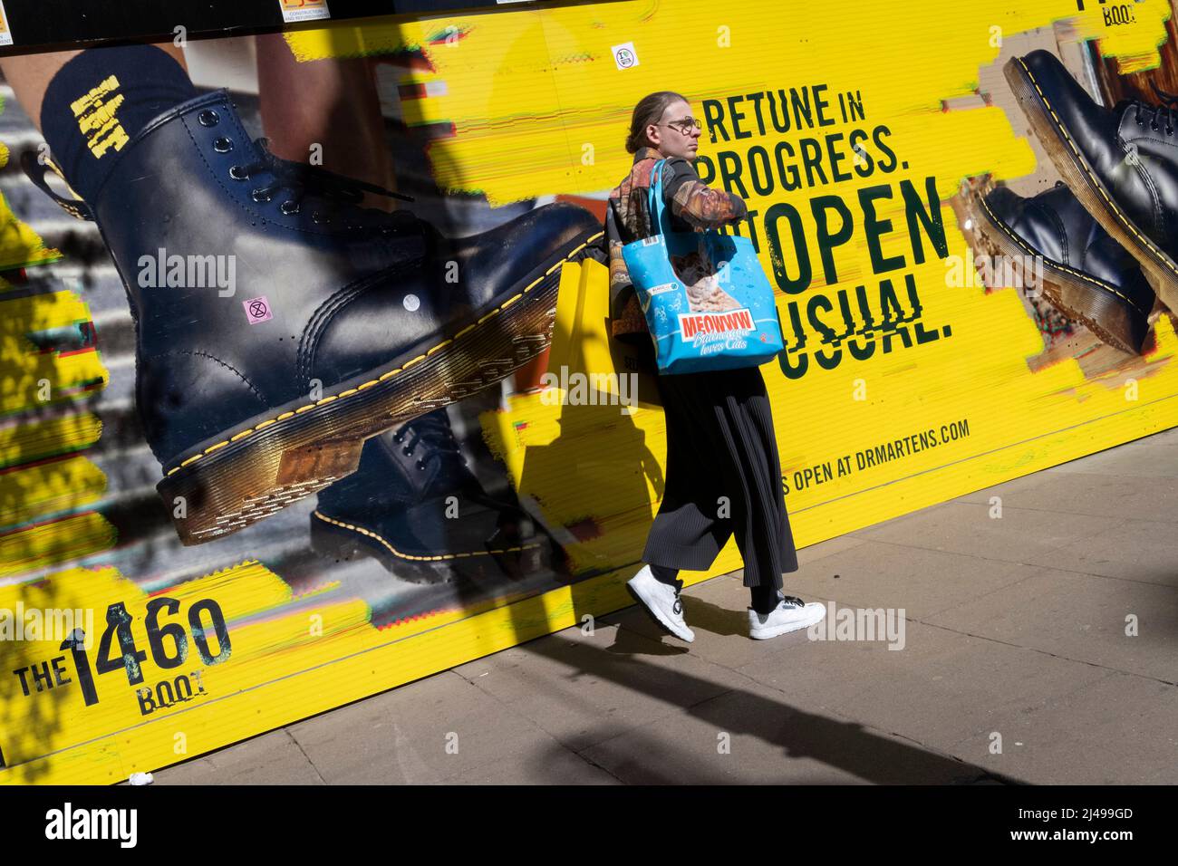 Shoppers walk past a billboard for the Doc Martens footwear brand on ...