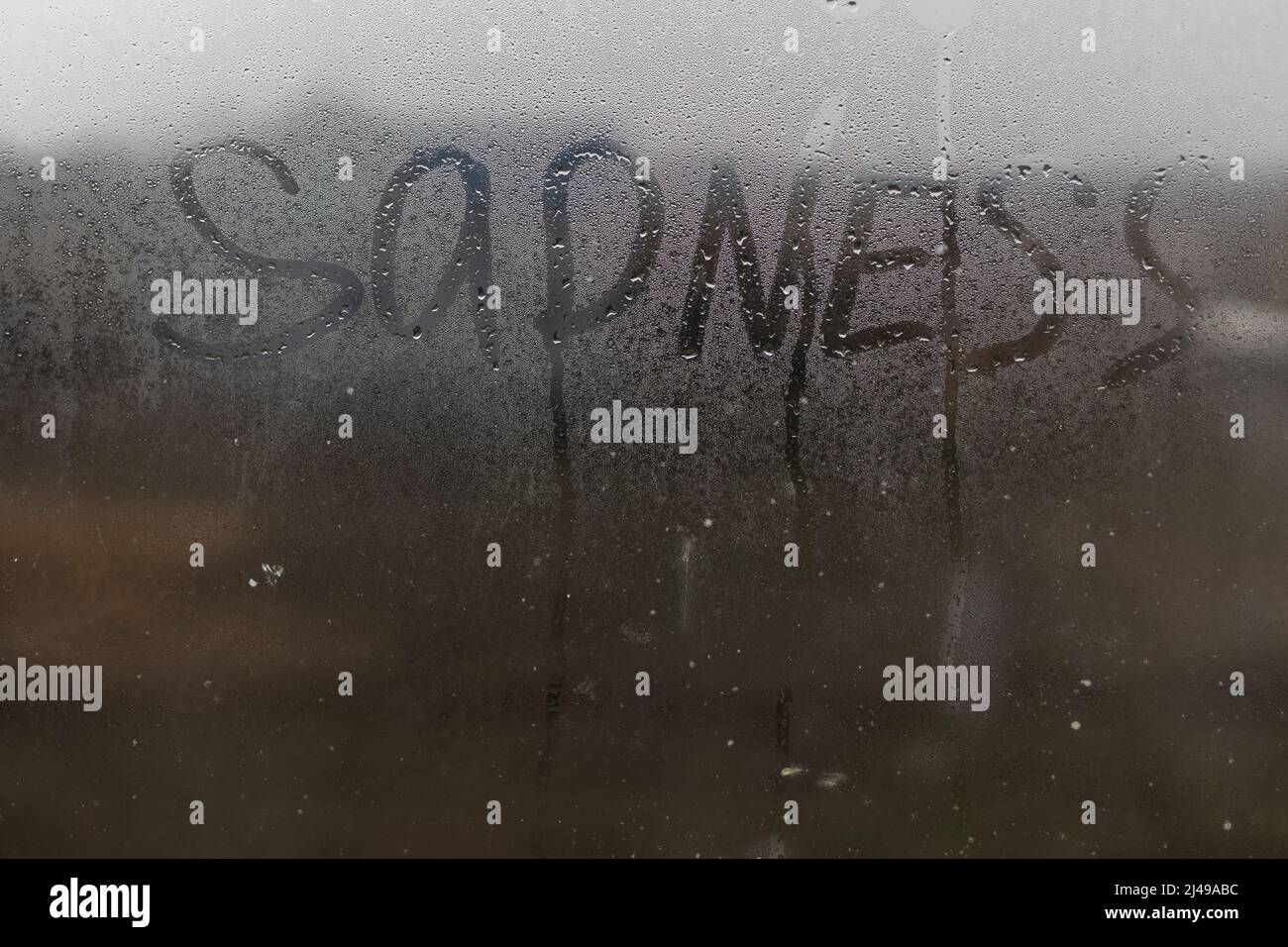 The inscription sadness on the wet window Stock Photo - Alamy