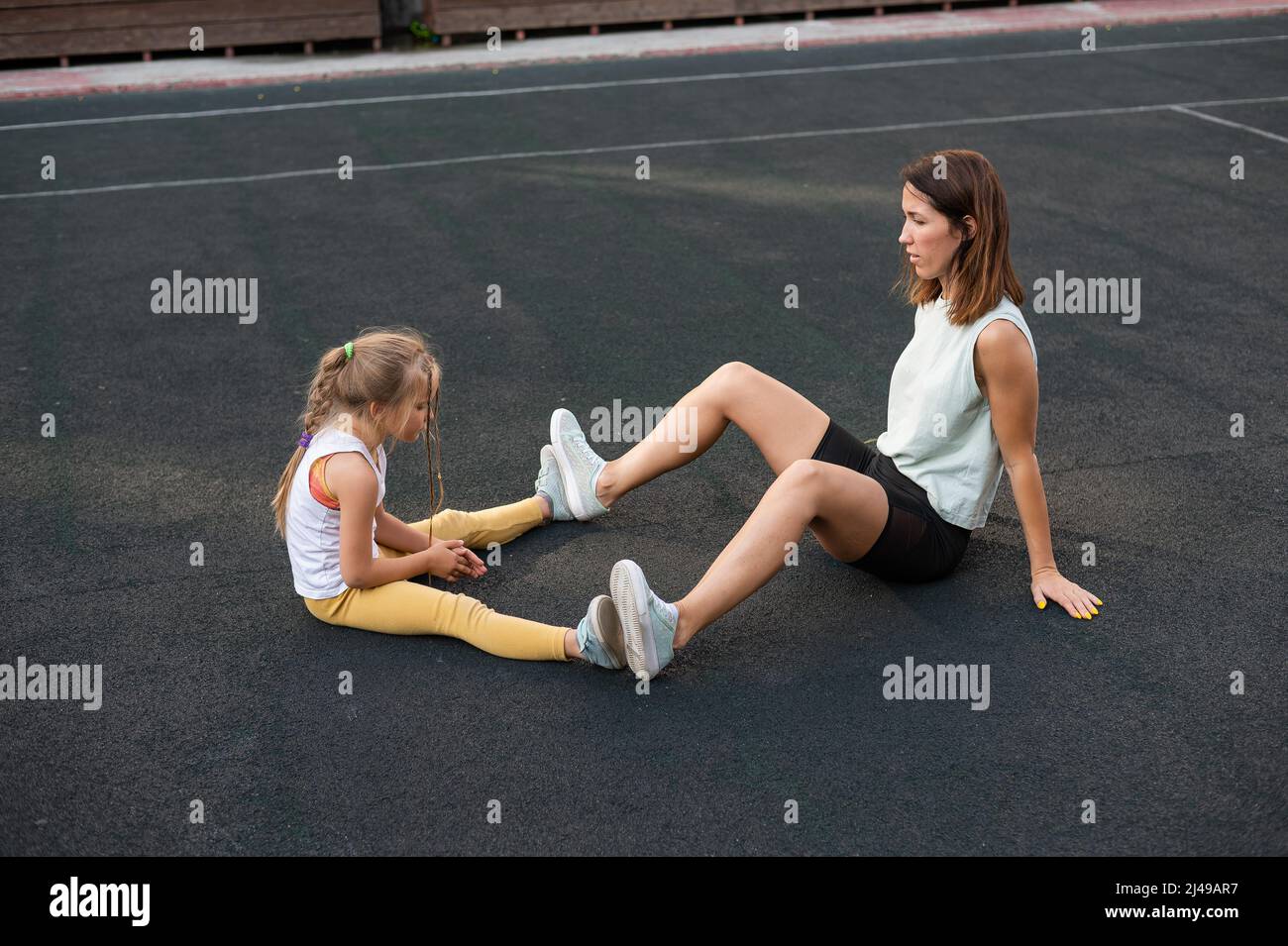 Mother and daughter go in for sports outdoors. Caucasian woman and ...