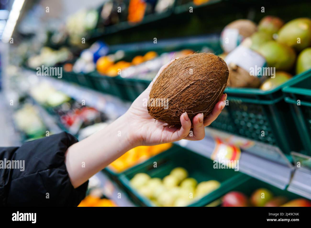 Woman customer choosing ripe coconut at supermarket. Close up Stock ...