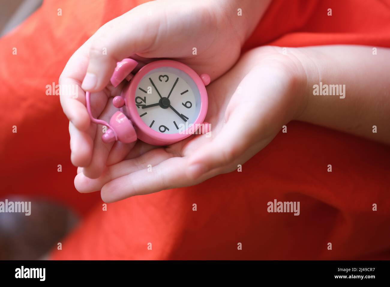 Pink clock compass in children hands closeup Stock Photo - Alamy