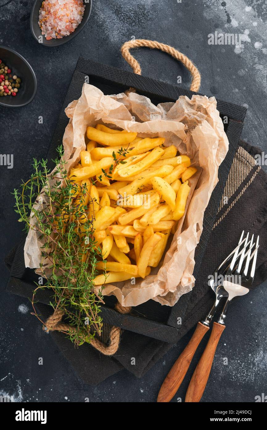 French fries. Tasty French fries server on parchment paper on wooden ...