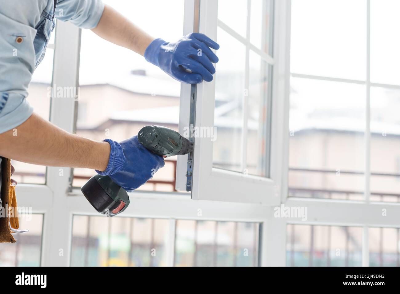 handyman adjusting white pvc plastic window indoors. worker using ...
