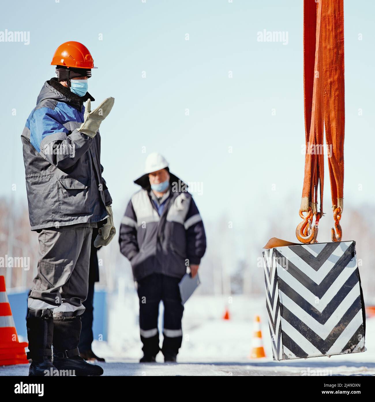 Engineer takes exam from slinger. Worker gestures to lift up control ...