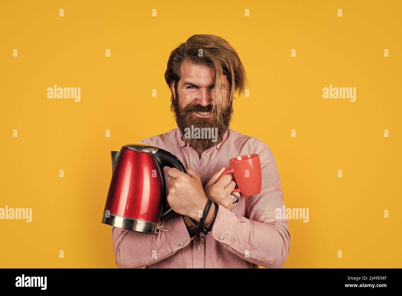 handsome bearded guy with stylish hair use electric kettle, morning ...