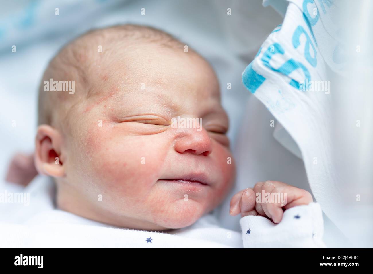 portrait of the face and small hand of a sleeping newborn baby with ...