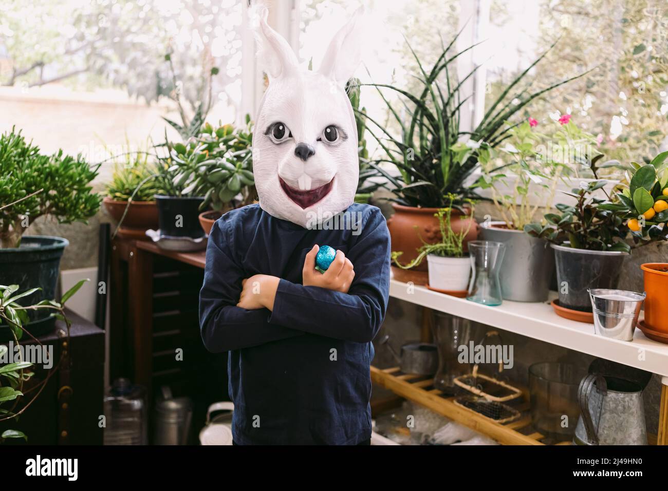 Girl celebrating Easter with a rabbit mask, arms crossed and some ...