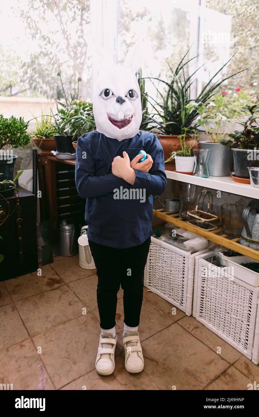 Girl celebrating Easter with a rabbit mask, arms crossed and some ...