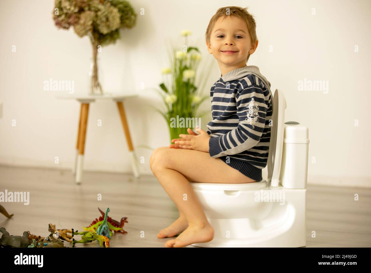 Cute toddler child, boy, using potty at home, while playing with toys ...