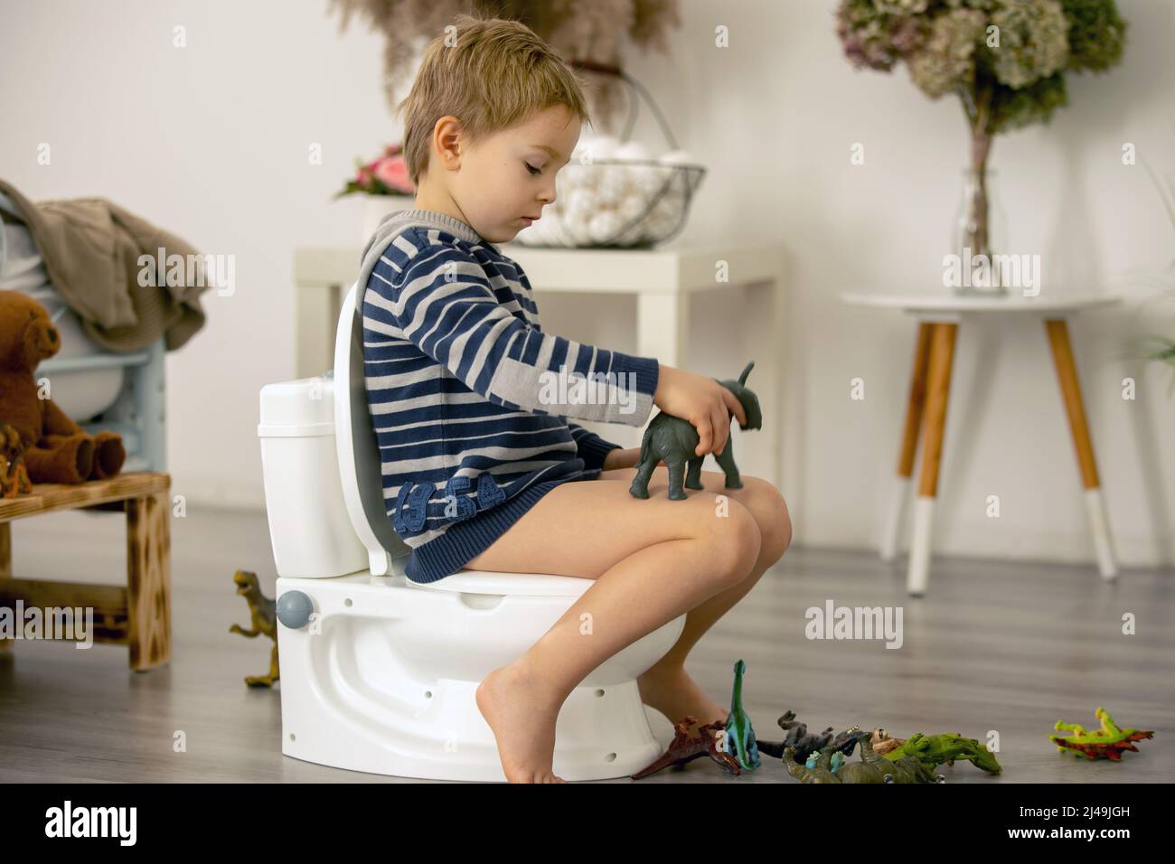 Cute toddler child, boy, using potty at home, while playing with toys ...