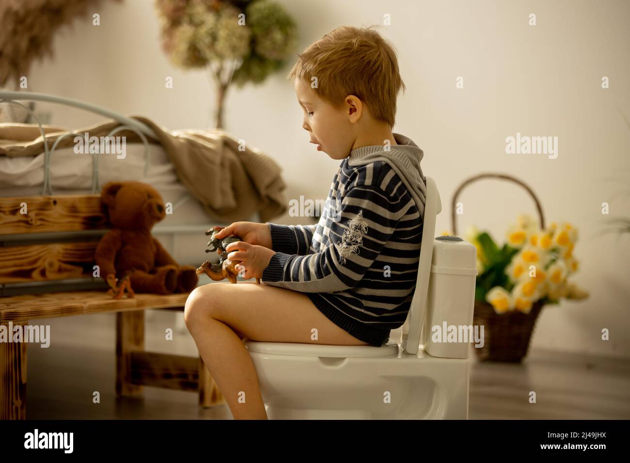 Cute toddler child, boy, using potty at home, while playing with toys ...
