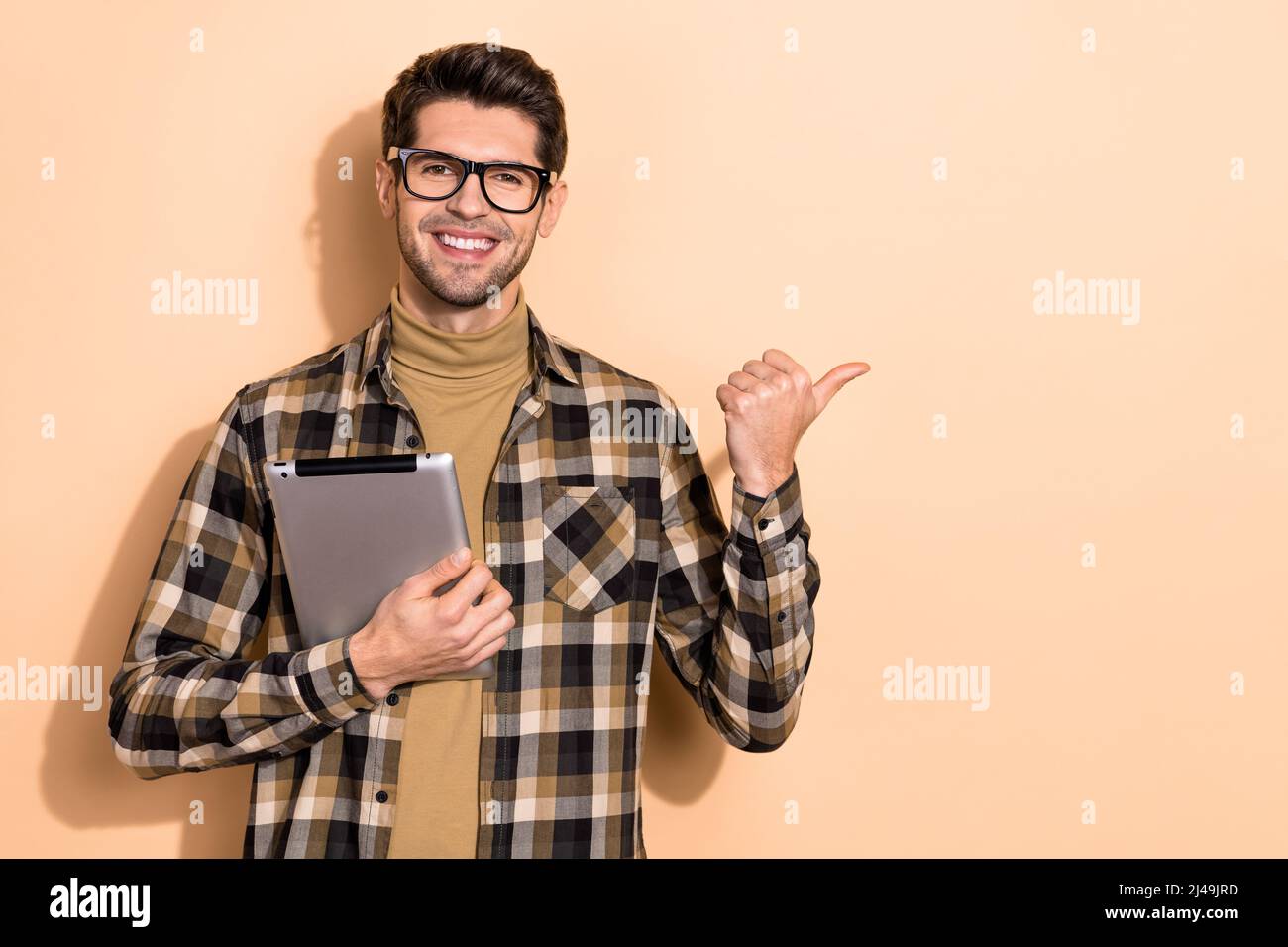 Photo of smart agent guy point empty space thumb hold tablet gadget ...