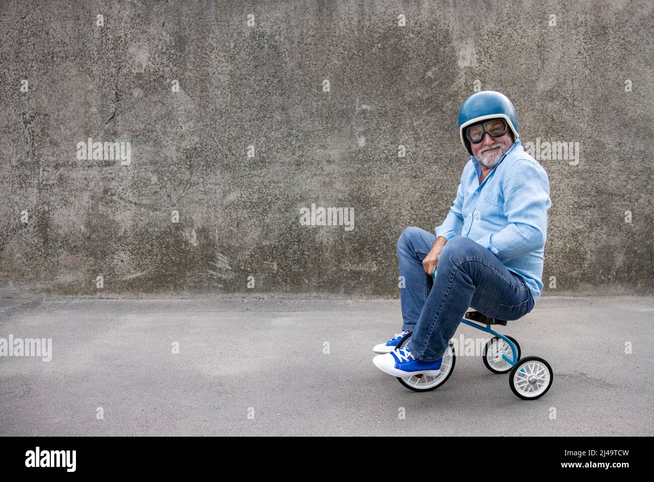 Portrait of funny businessman outdoor. Senior man riding retro trike ...
