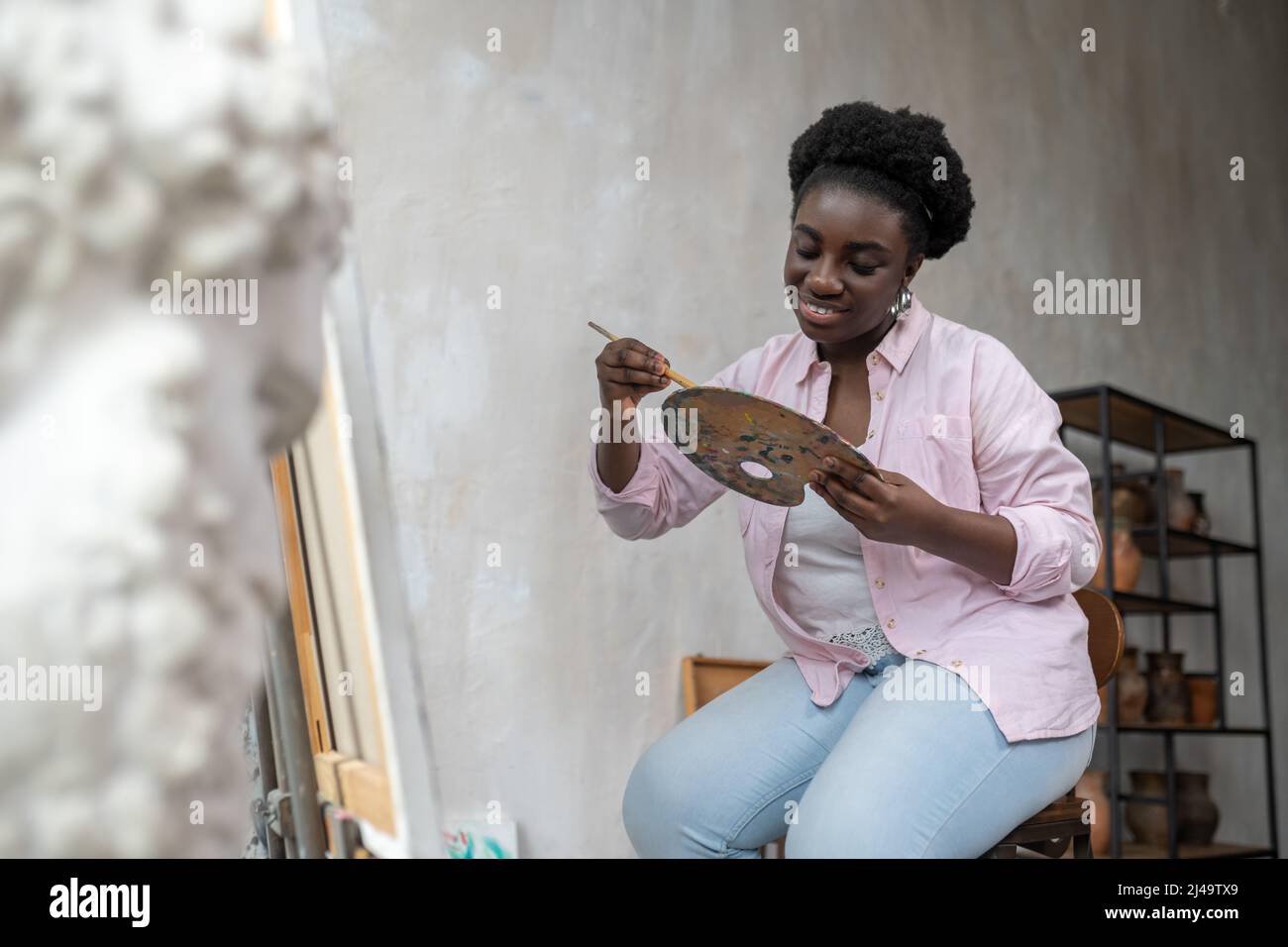 A smiling dark-skinned artist mixing colors on palette Stock Photo - Alamy