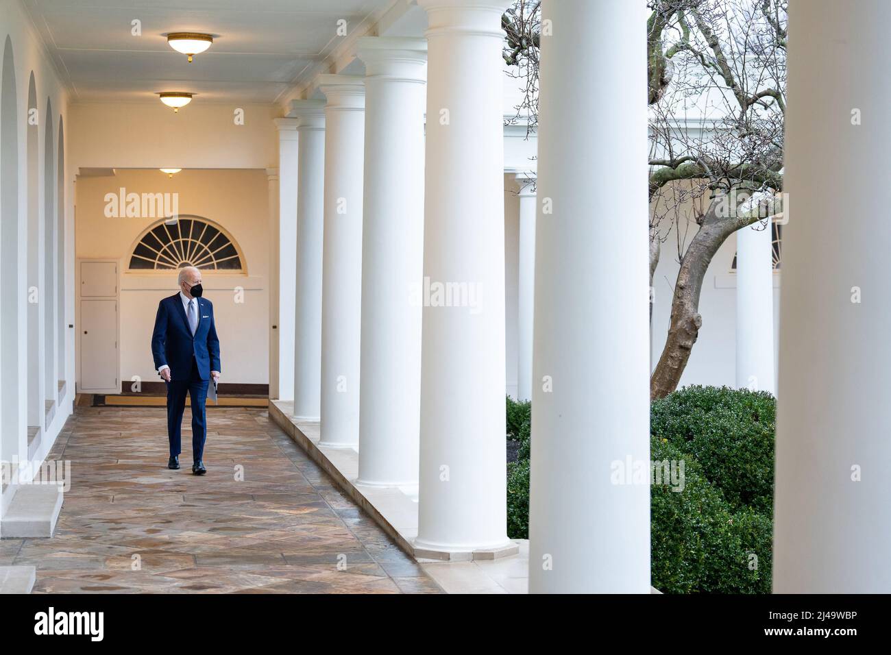 President Joe Biden walks along the West Colonnade of the White House ...