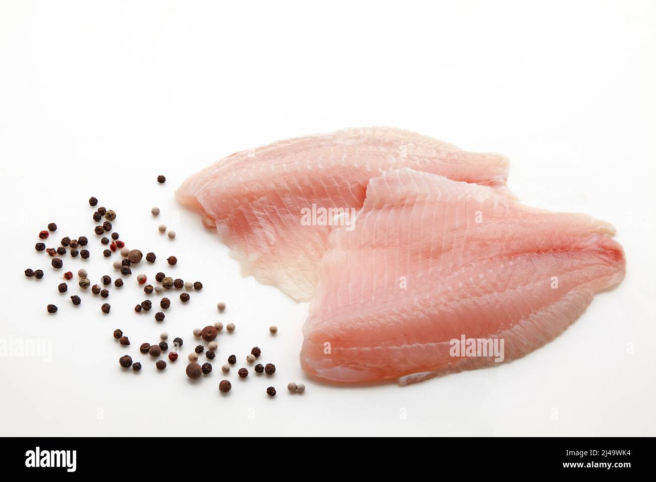Prepared white fish fillet and pepper drops mix isolated on white ...