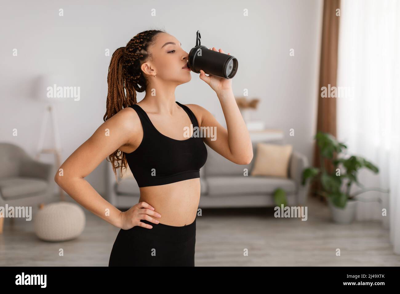 Sporty Black Woman Drinking Water Hydrating During Workout At Home Stock Photo - Alamy