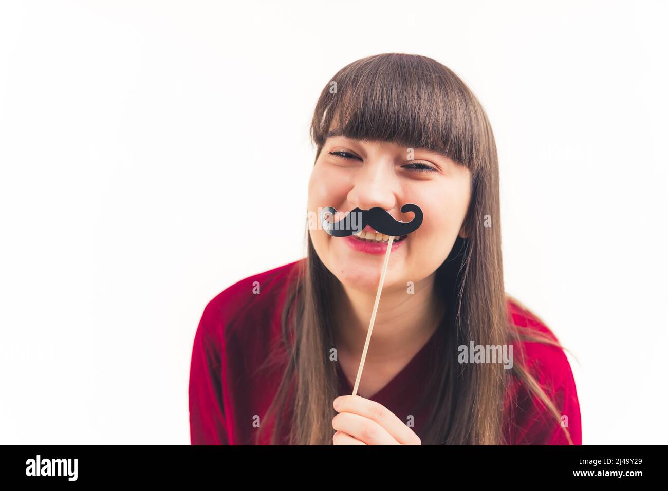 Funny caucasian woman looking at camera and holding fake black ...