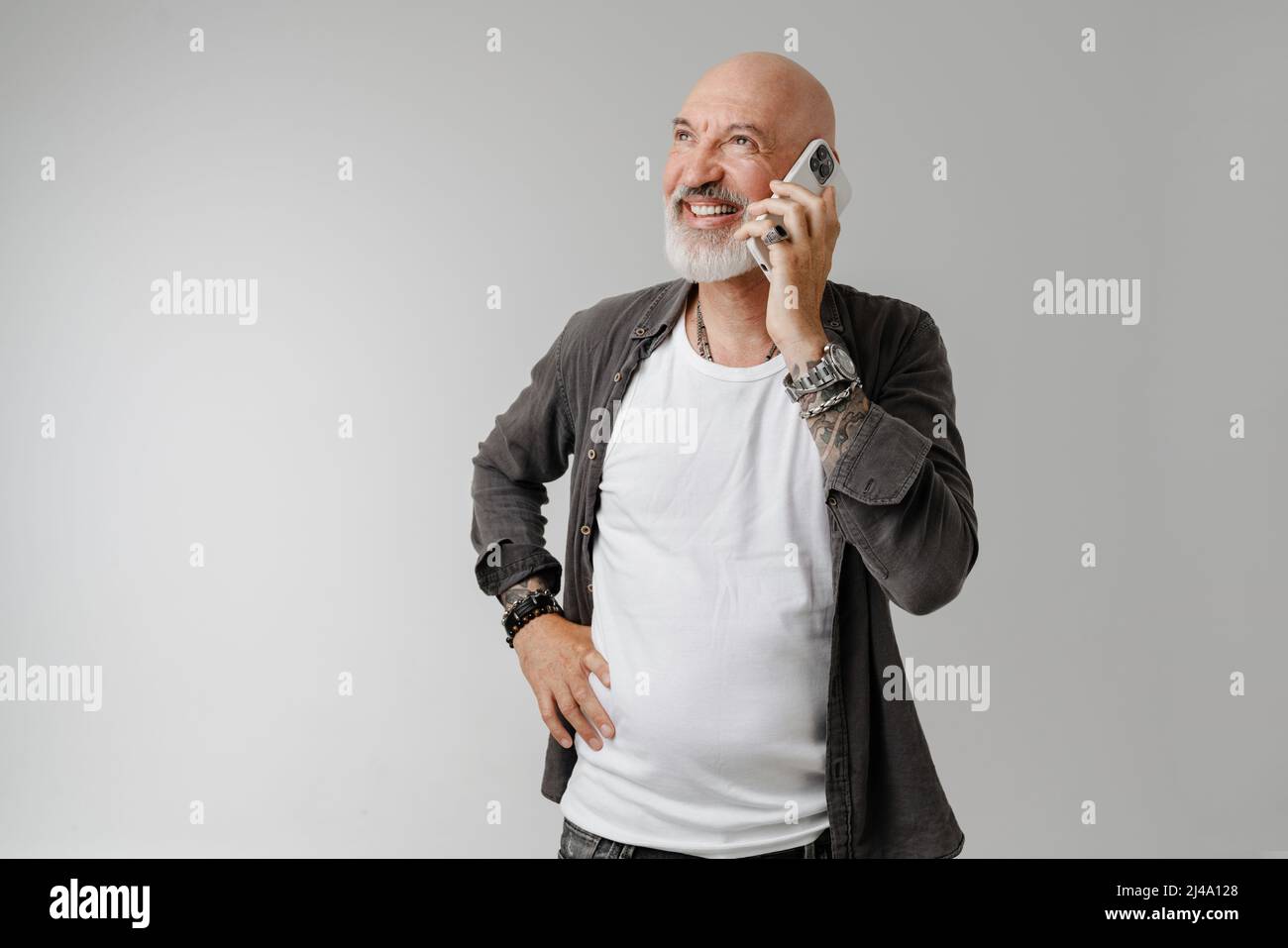 Bald european man with beard talking on using mobile phone isolated ...