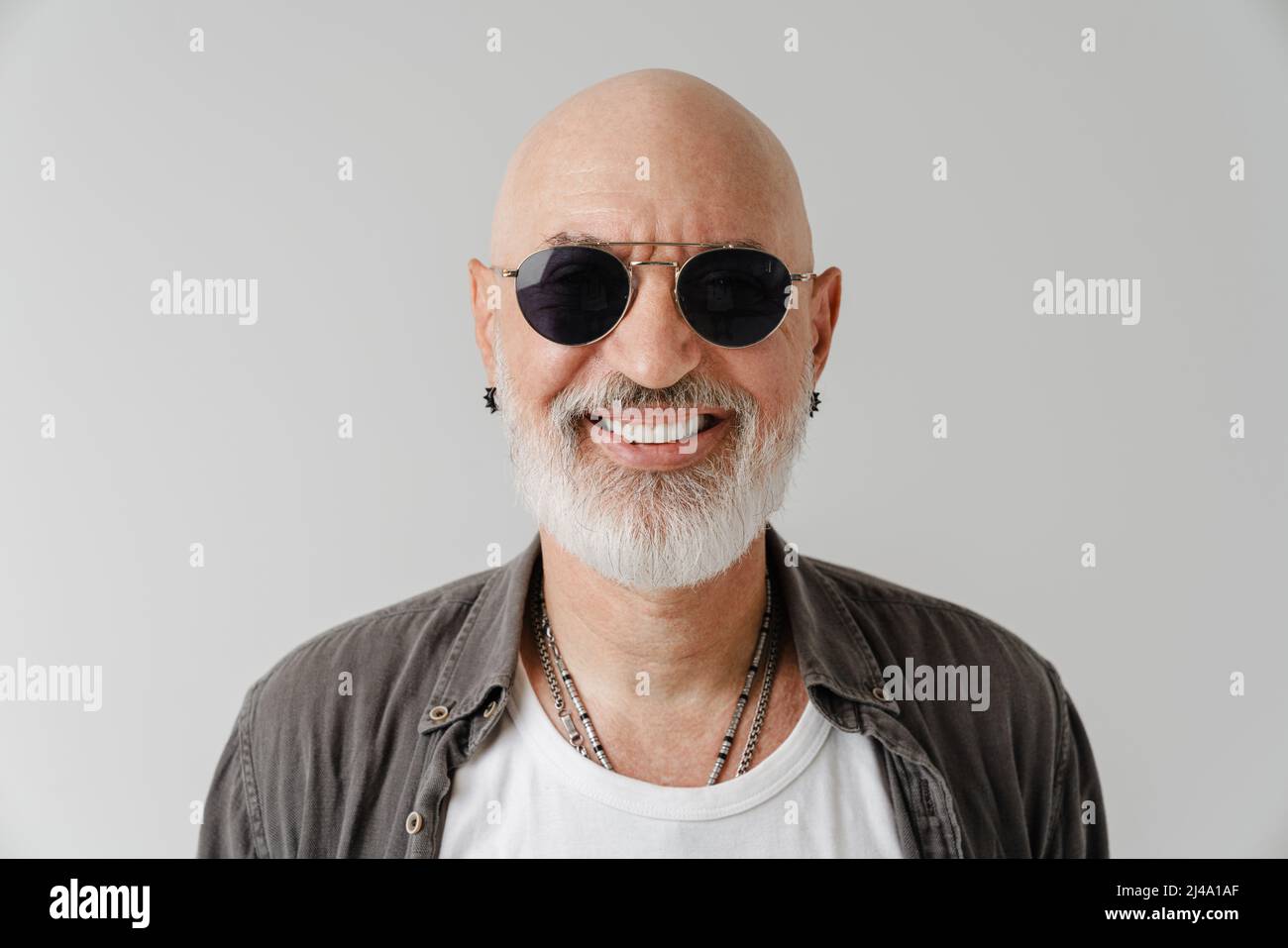 Bald european man in sunglasses laughing and looking at camera isolated ...