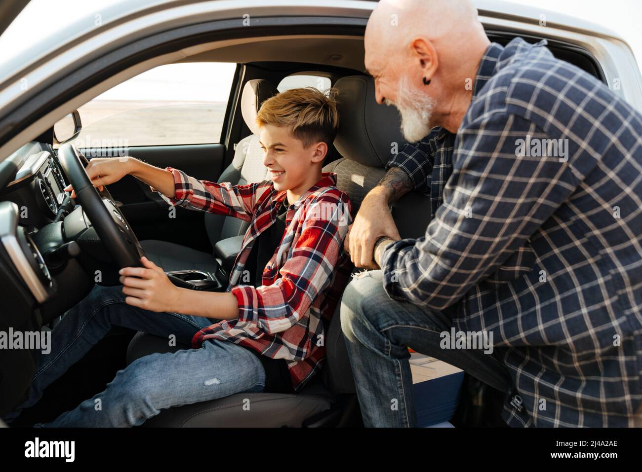 Happy middle aged father and his preschooler son sitting in a car ...