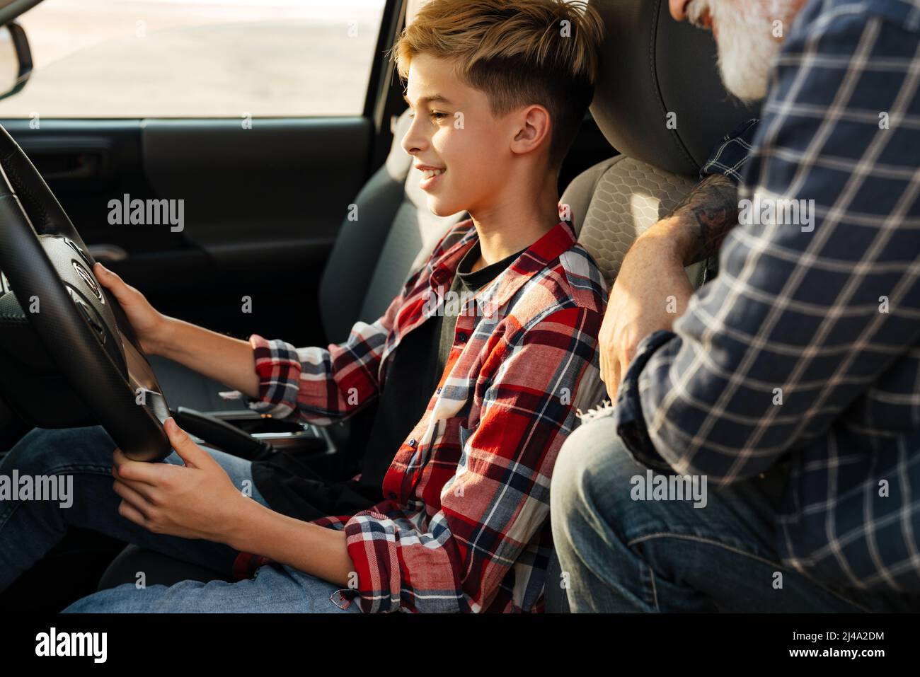 Happy middle aged father and his preschooler son sitting in a car ...