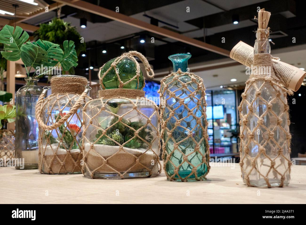 Glass bottles wrapped in string forming an ornate counter display Stock ...
