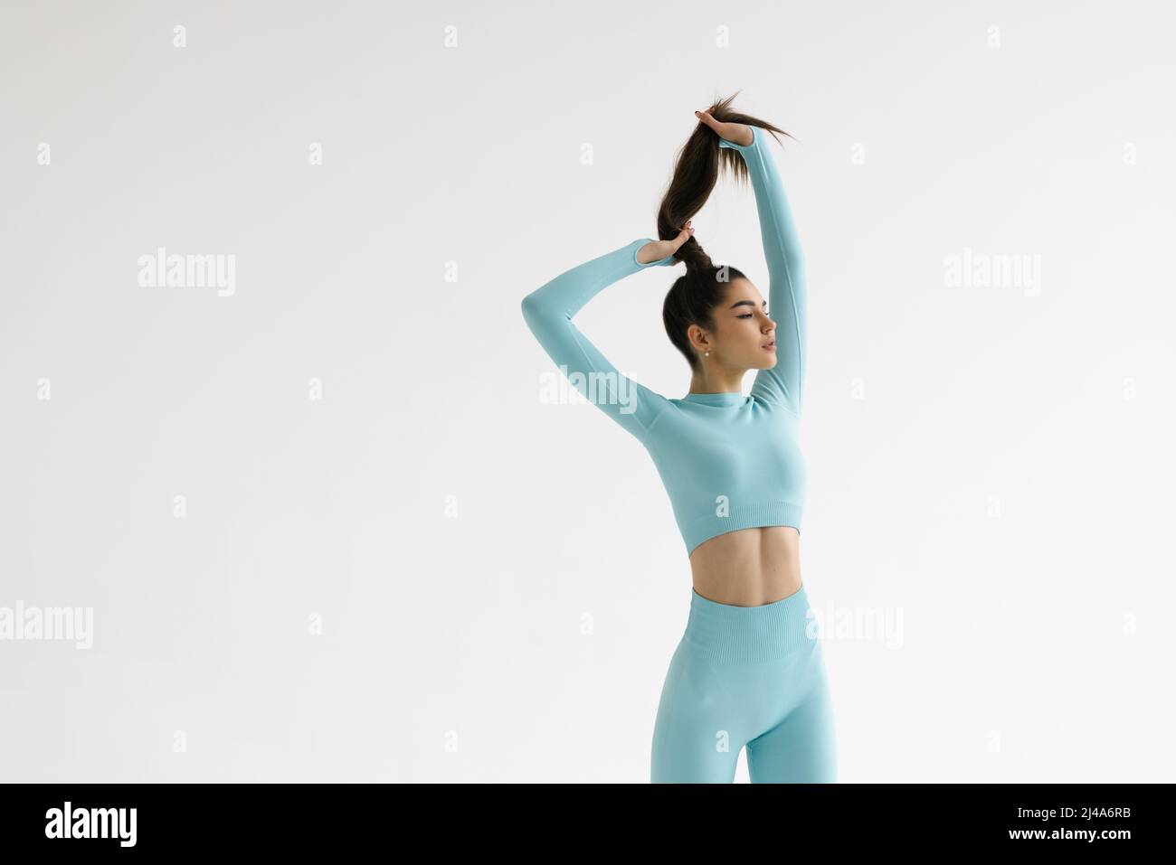 Sporty slim woman with ponytail enjoys workout exercise in purple sport ...